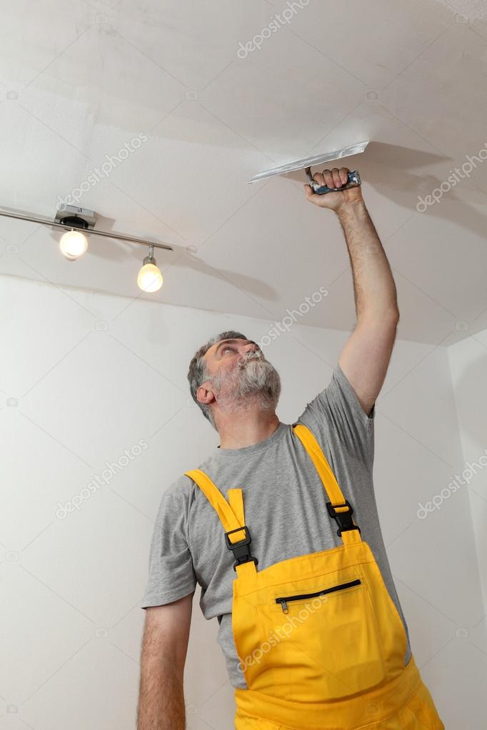 Worker repairing plaster at ceiling — Stock Photo © simazoran #60622721