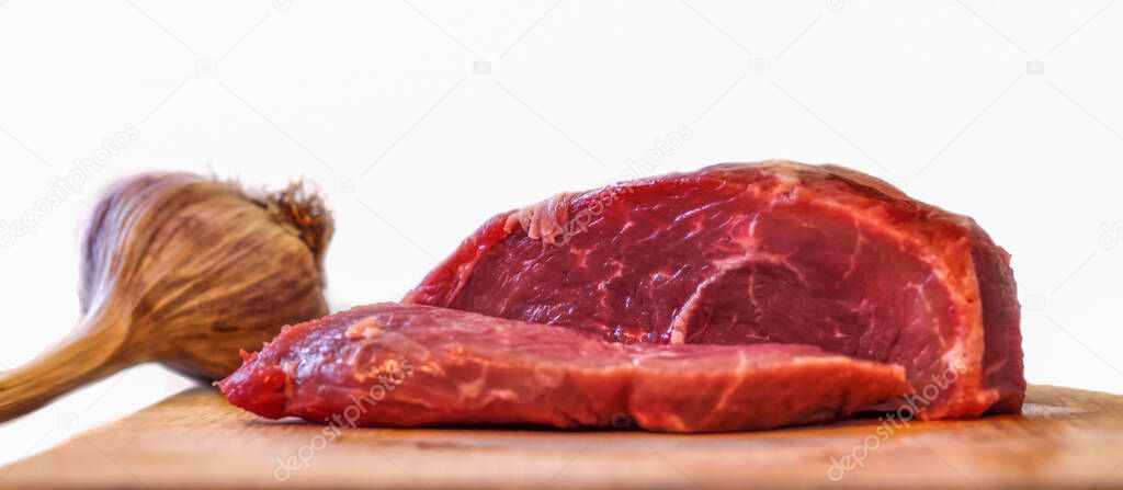 un trozo de carne de res en una tabla de cortar de madera con una ...