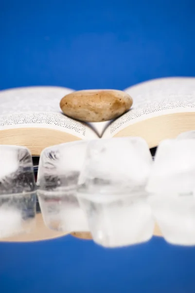 Book open with a single stone on it - Stock Image - Everypixel