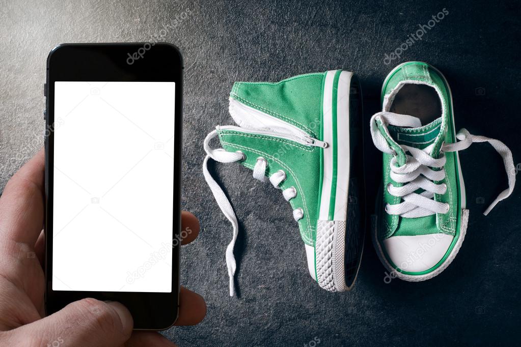 Sneakers for kids and screen on the smart phone Stock Photo by ...