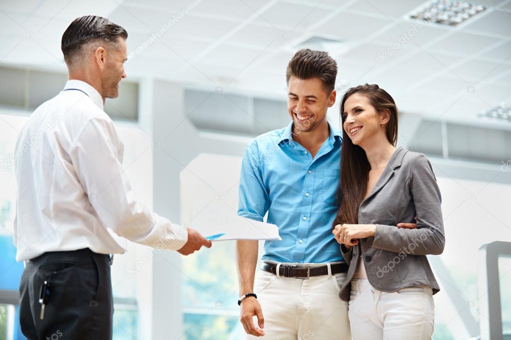 Car Salesman Invites Customers at Showroom. ⬇ Stock Photo, Image by ...