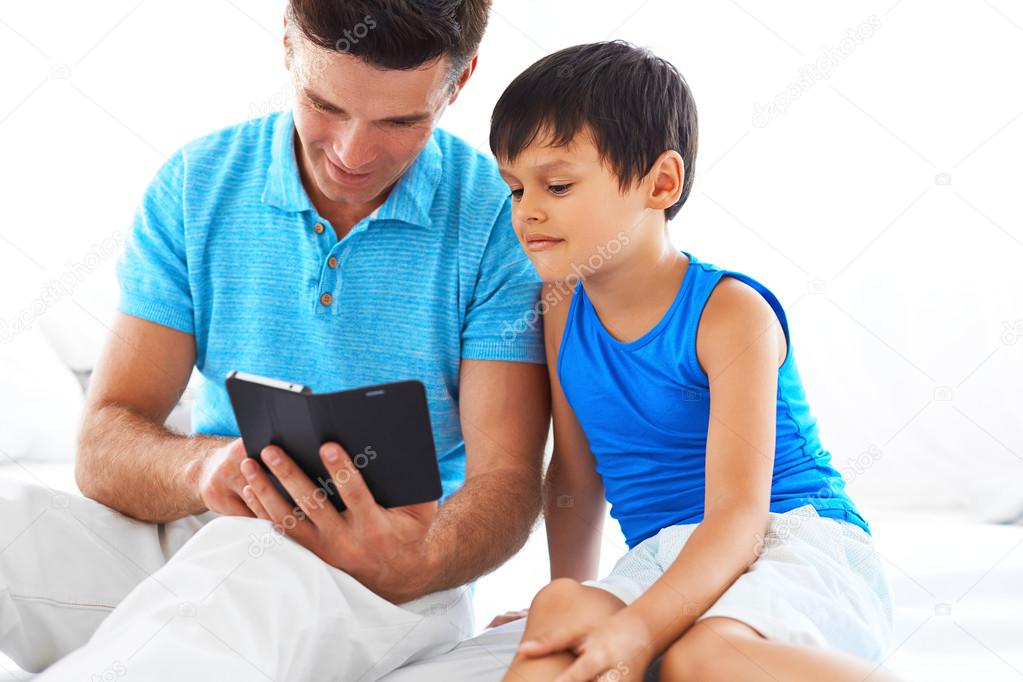 Father and son using mobile phone Stock Photo by ©puhhha 87335210