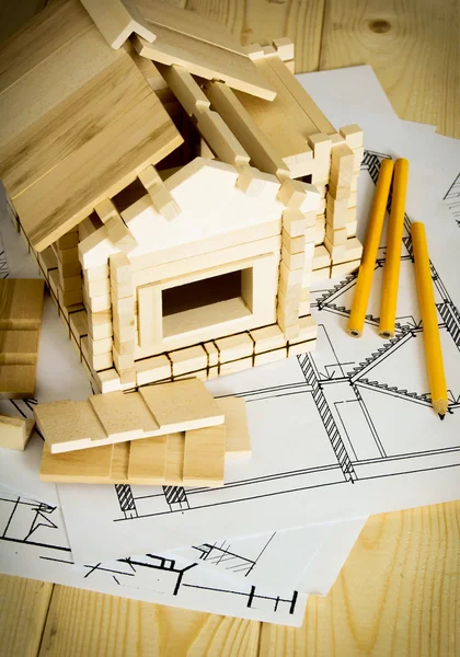 Many drawings for building, pencils and small house on wooden ...