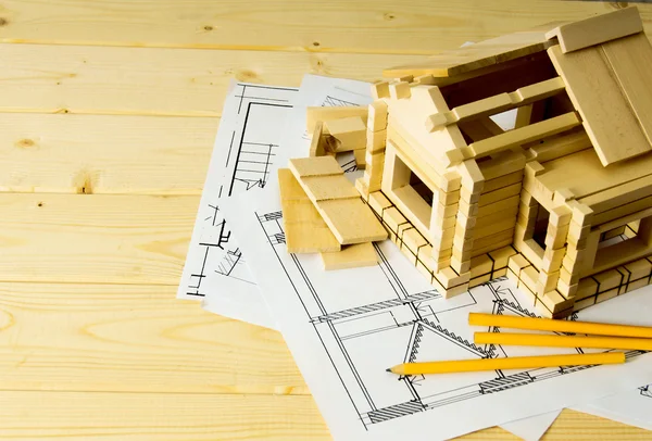 Many drawings for building, pencils and small house on wooden ...