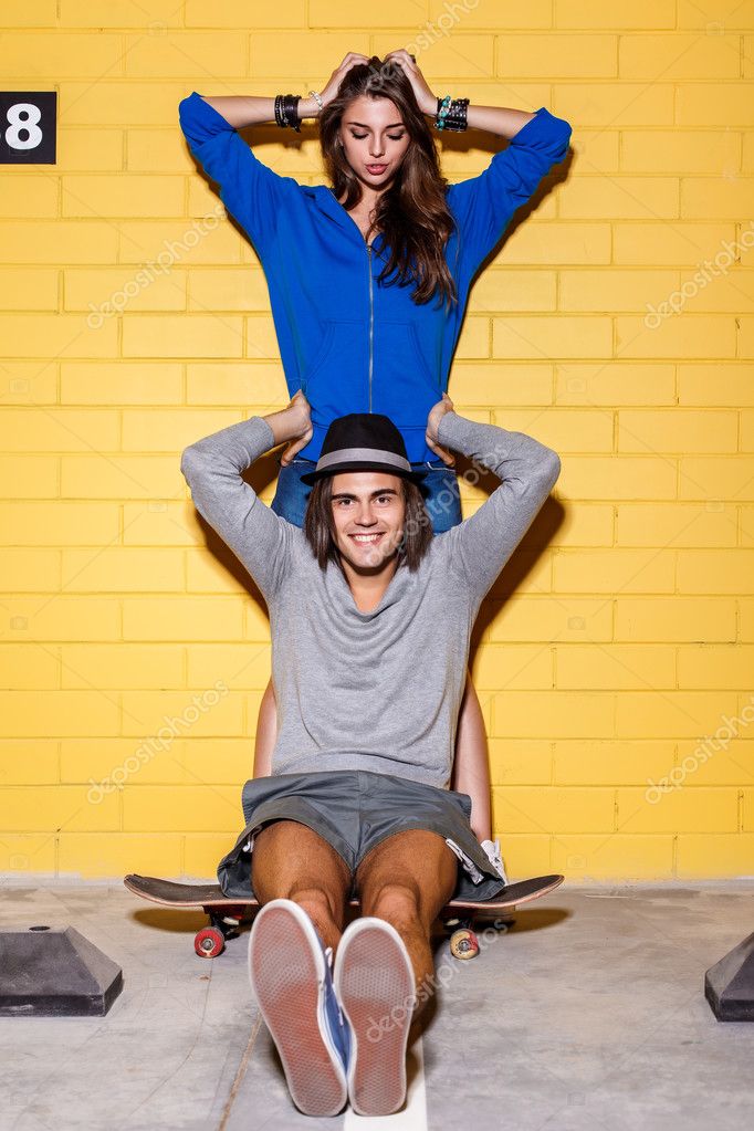 Happy young couple having fun in front of yellow brick wall — Stock ...