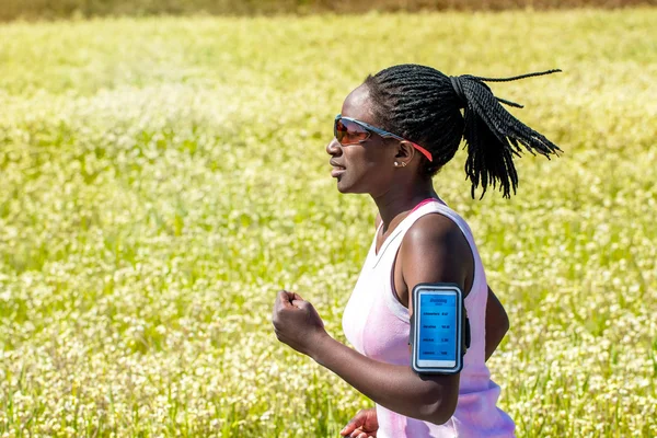 African woman tracking running on smart phone. - Stock Image - Everypixel