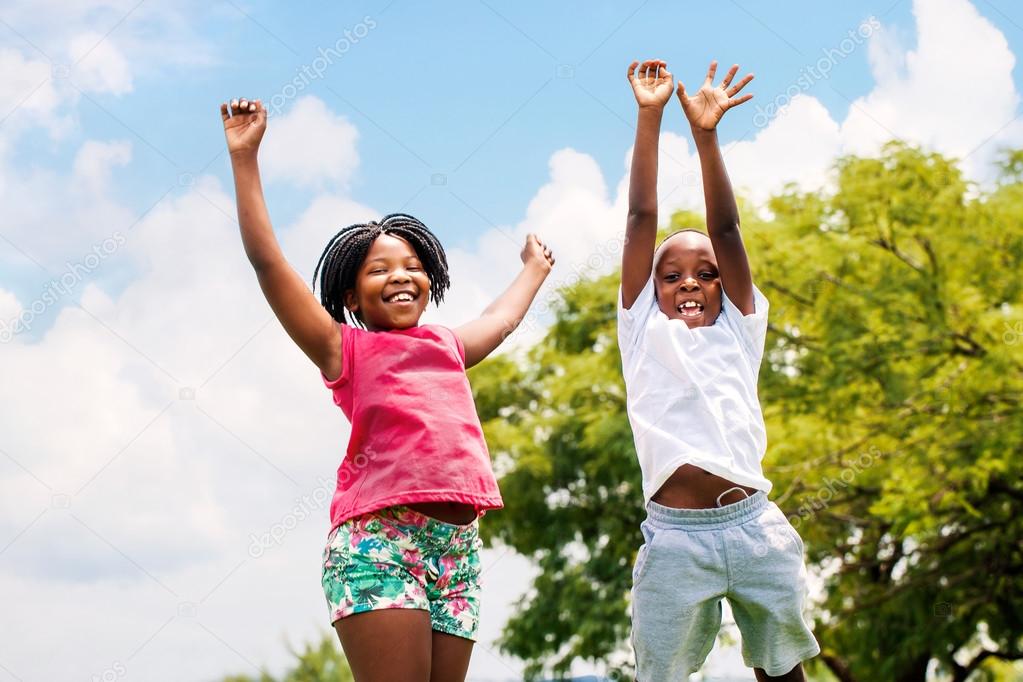 Two African kids jumping in park. — Stock Photo © karelnoppe #64619623