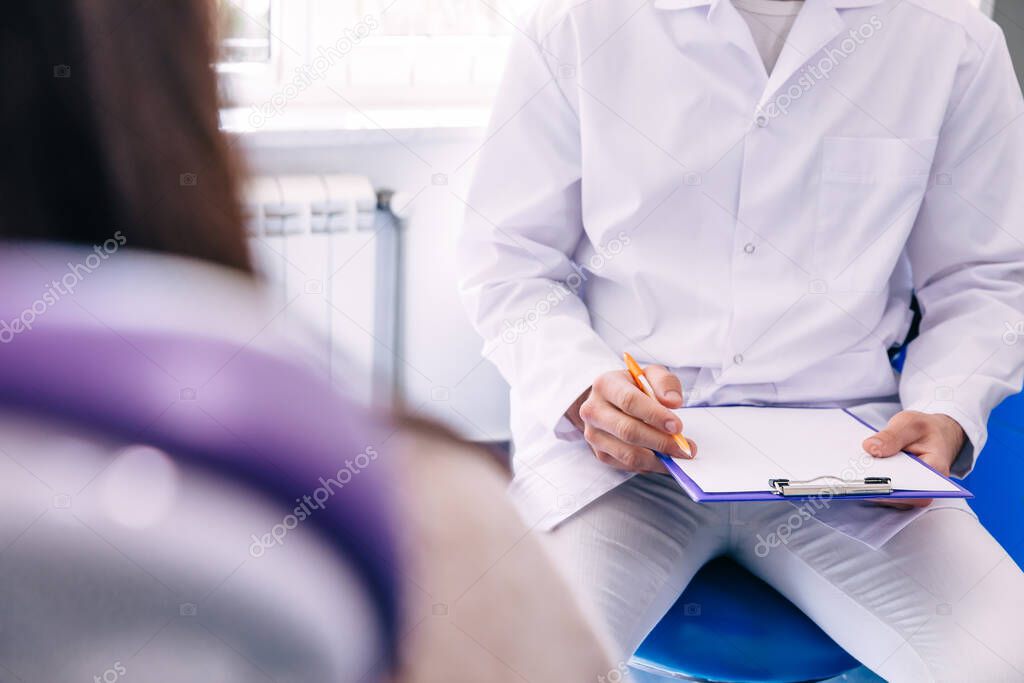 doctor escribe las respuestas del paciente y sentado en la silla ...