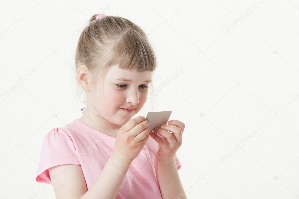 Pretty little girl reading the text on a card Stock Photo by ...