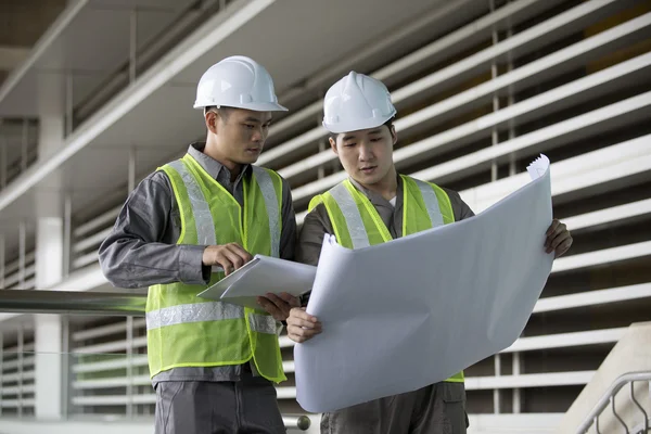 Chinese industrial engineers looking at plans - Stock Image - Everypixel
