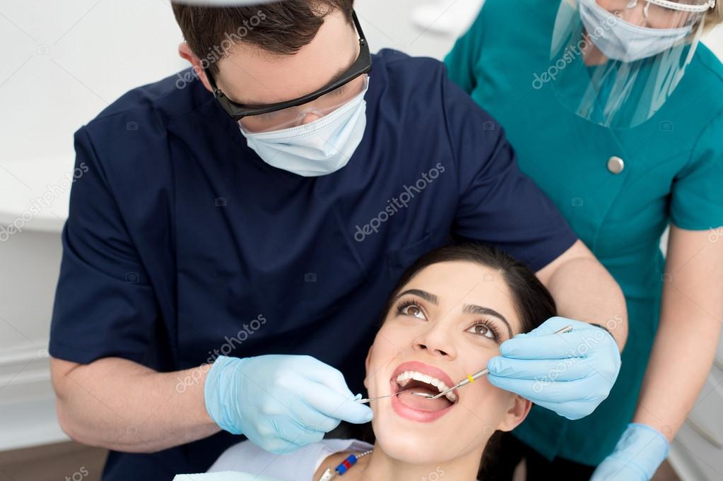 Female patient getting teeth cleaning Stock Photo by ©stockyimages 91523276