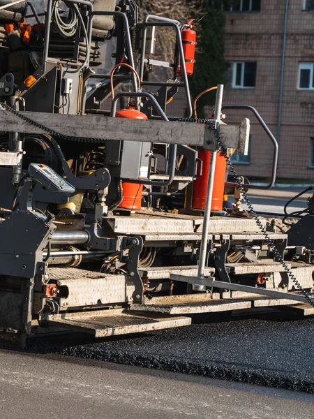 Industrial asphalt paver machine laying fresh asphalt on road ...