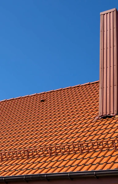 Red corrugated metal profile roof installed on a modern house. The roof ...