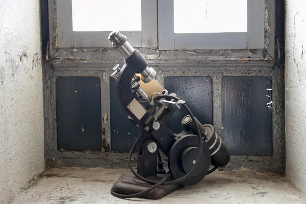 Antique microscope on a decrepit window sill - Stock Image - Everypixel