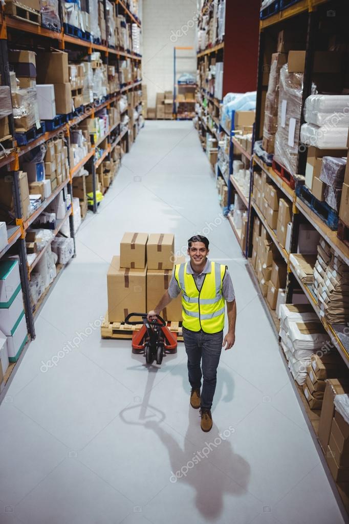 Worker pulling trolley with boxes Stock Photo by ©Wavebreakmedia 100546670