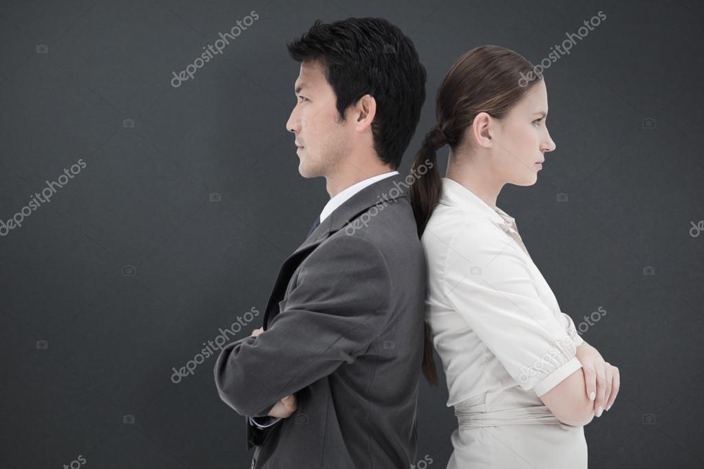 Serious business people standing back-to-back Stock Photo by ...