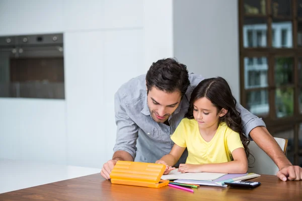 Father assisting her daughter in doing her homework Stock Photo by ©Wavebreakmedia 139905362