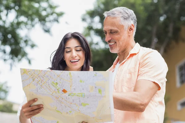 Cheerful couple reading map - Stock Image - Everypixel