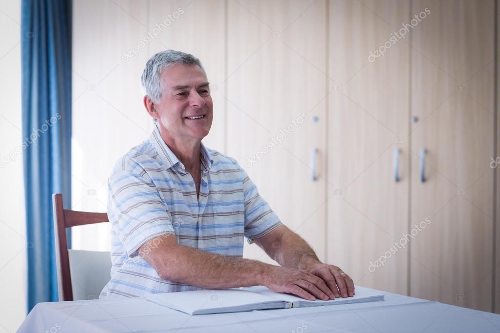 Blind man reading a braille book Stock Photo by ©Wavebreakmedia 112933402