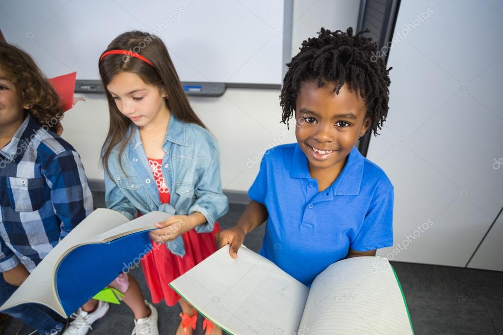 Kids reading book in classroom Stock Photo by ©Wavebreakmedia 115230178