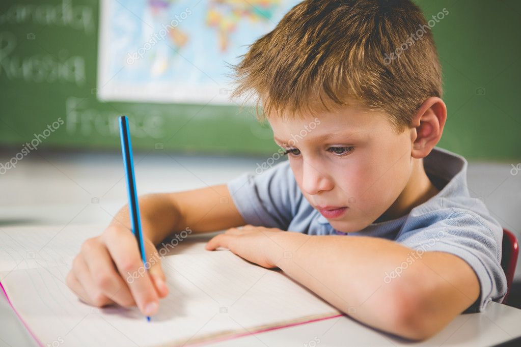 Schoolboy doing homework in classroom Stock Photo by ©Wavebreakmedia ...