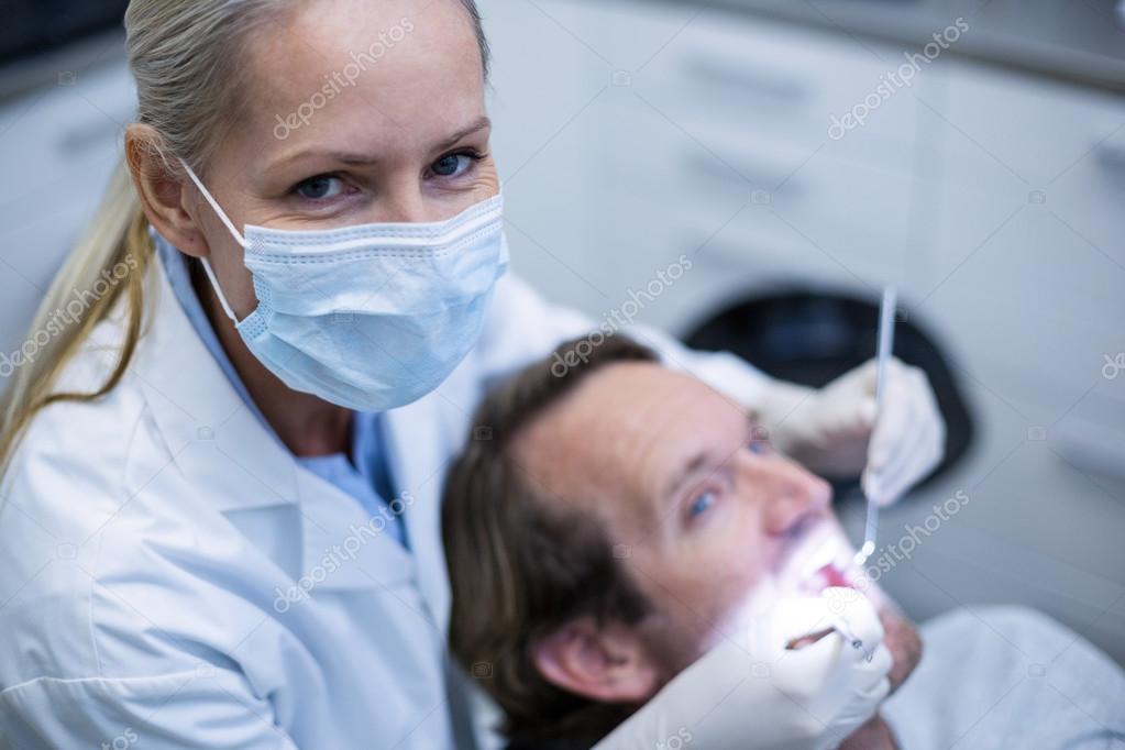 Dentist examining a patient with tools — Stock Photo © Wavebreakmedia ...