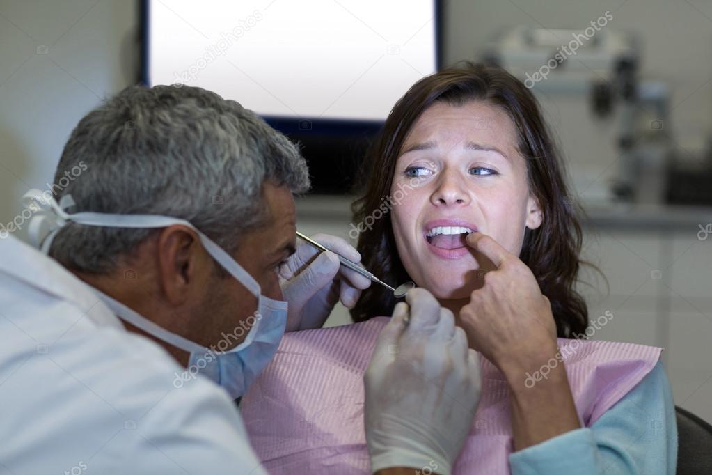Dentist examining a female patient with tools — Stock Photo ...