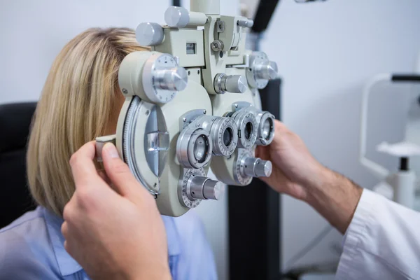 Female patient under going eye test through phoropter - Stock Image ...