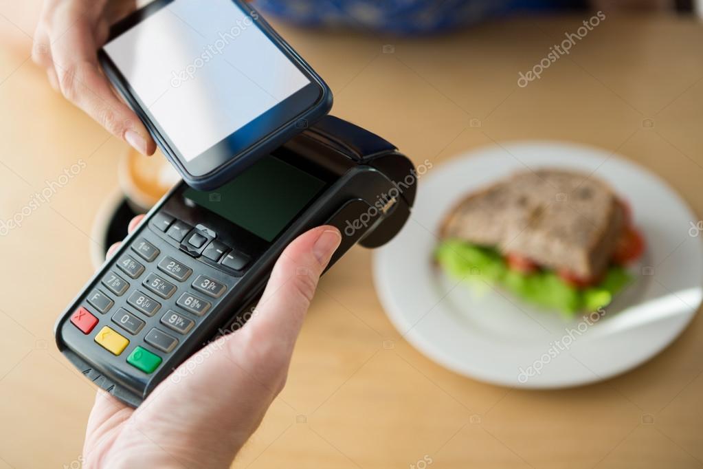 Hand making a payment through NFC technology Stock Photo by ...