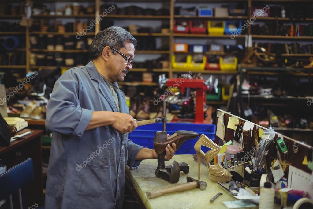 Shoemaker hammering on a shoe — Stock Photo © Wavebreakmedia #123941294