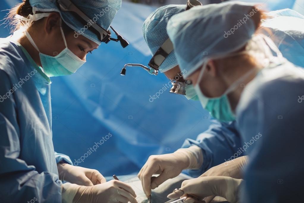 Surgeons performing operation in operation room Stock Photo by ...