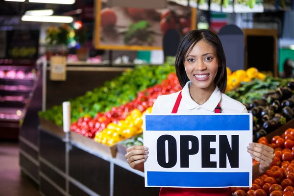 Female staff holding open signboard - Stock Image - Everypixel