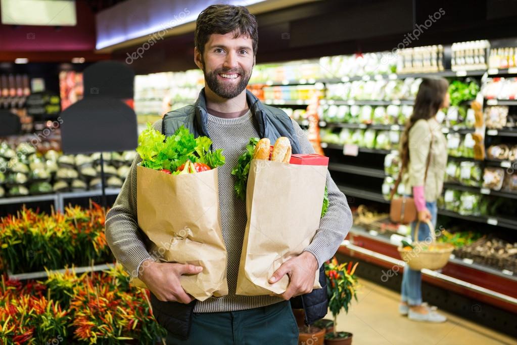 Man holding grocery bag in organic section Stock Photo by ...