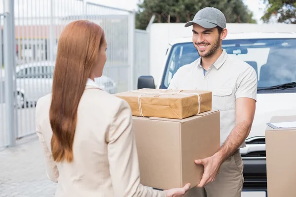 Delivery driver passing parcels to customer - Stock Image - Everypixel