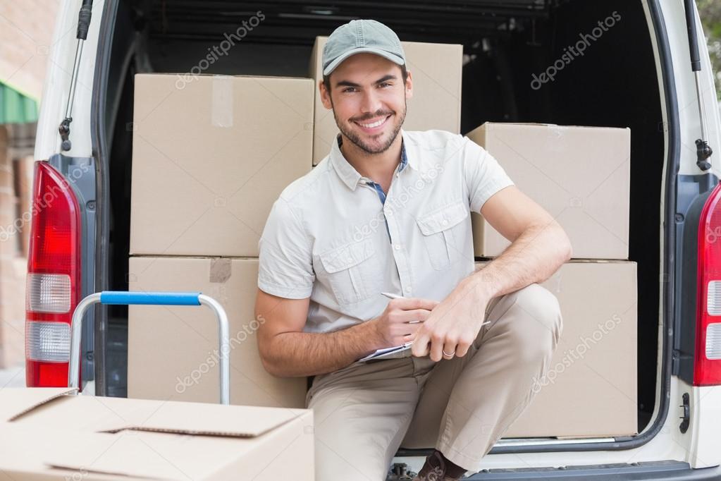 Delivery driver writing in clipboard Stock Photo by ©Wavebreakmedia ...