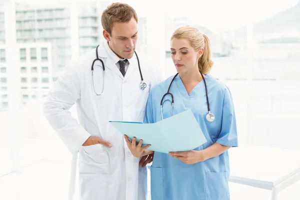 Male doctor and surgeon looking at reports - Stock Image - Everypixel
