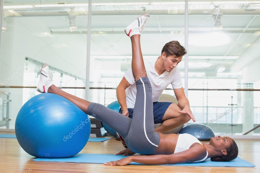 Personal trainer working with client using exercise ball — Stock Photo ...