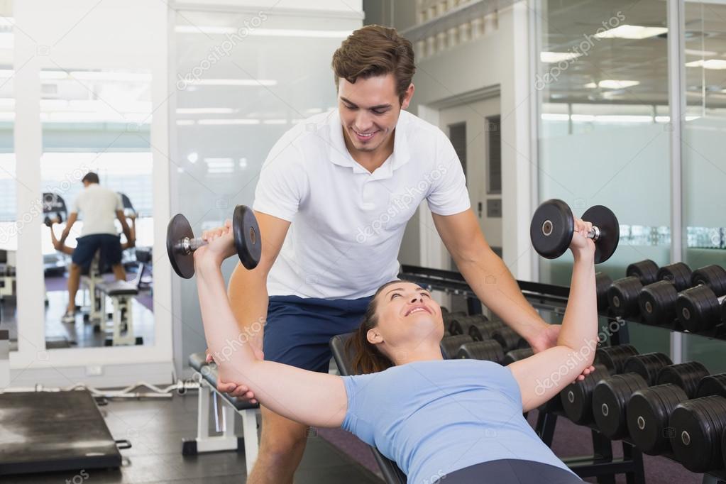 Personal trainer helping client lift dumbbells — Stock Photo ...