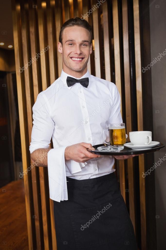 Sonriente mesero sostiene la bandeja con taza de café y cerveza — Foto ...