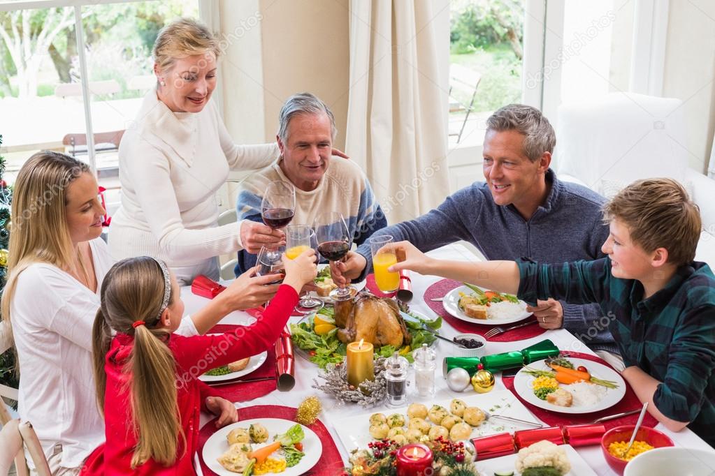 Family toasting with red wine in a christmas dinner Stock Photo by ...