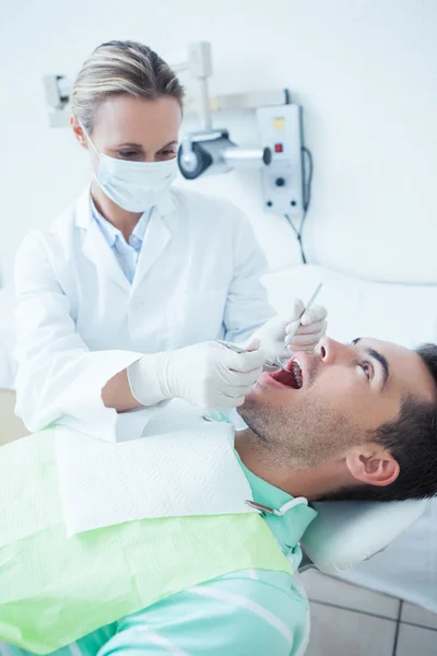 Male dentist with assistant examining girls teeth Stock Photo by ...