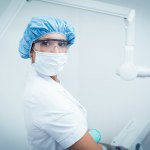 Female dentist wearing surgical mask and safety glasses Stock Photo by ...