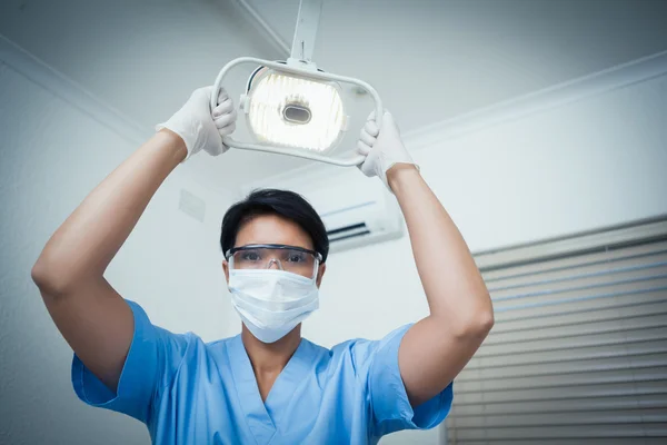 Female dentist adjusting light Stock Photo by ©Wavebreakmedia 65284963