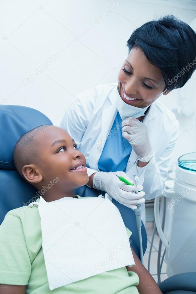 Smiling female dentist examining boys teeth Stock Photo by ...