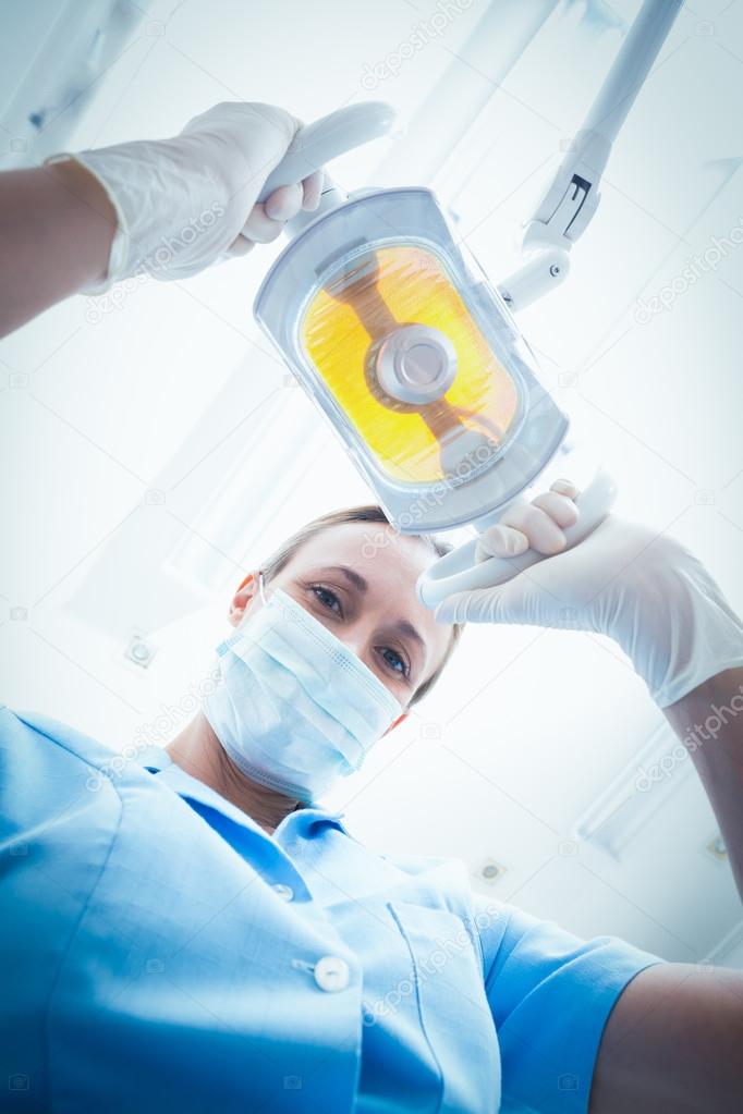 Portrait of female dentist adjusting light Stock Photo by ...