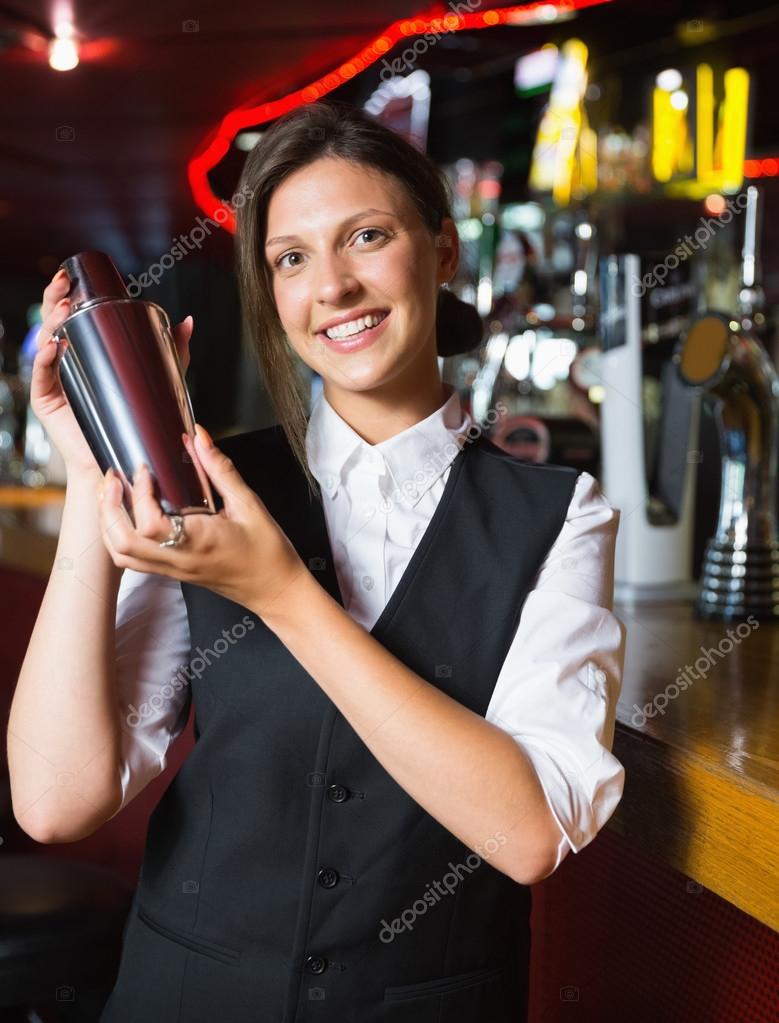Happy barmaid smiling at camera making cocktail Stock Photo by ...