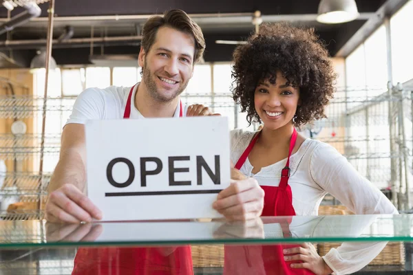 Smiling team posing behind the counter with open sign - Stock Image ...