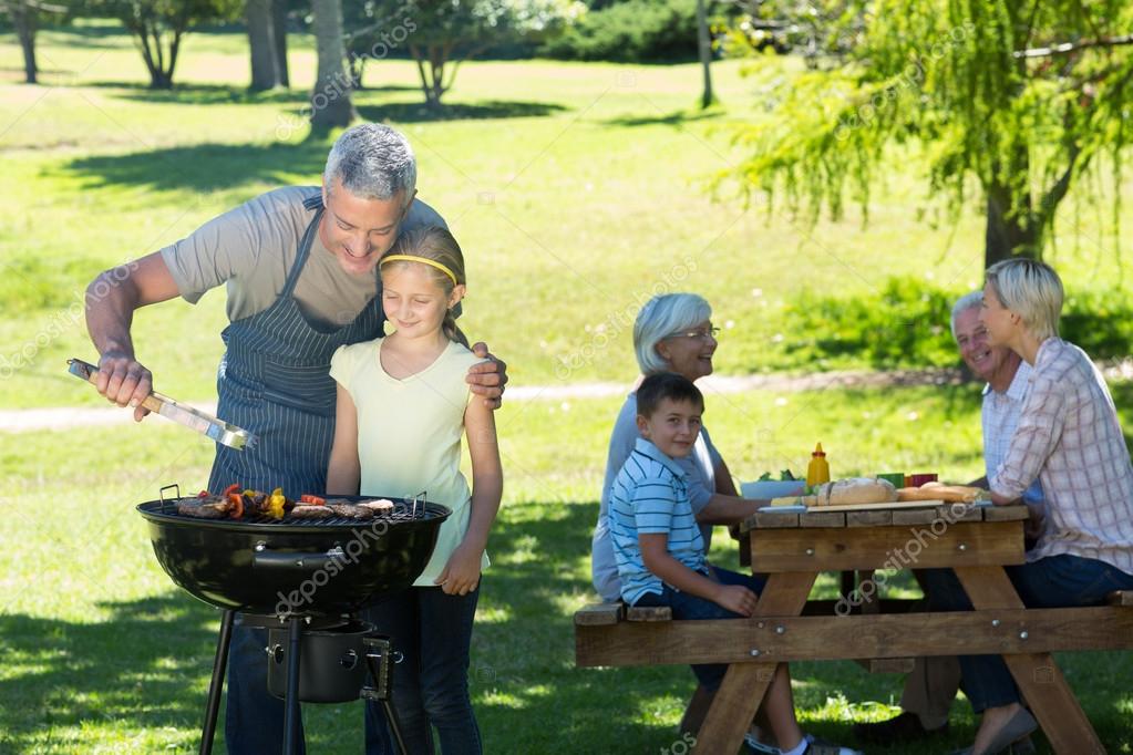 Happy father doing barbecue with his daughter — Stock Photo ...