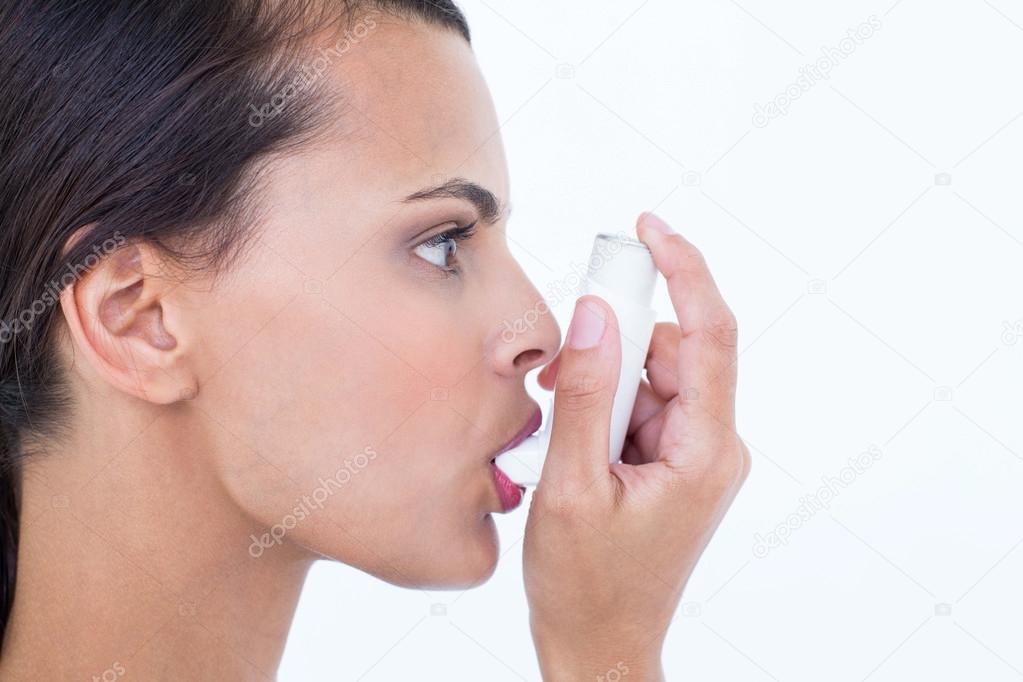 Beautiful using her inhaler — Stock Photo © Wavebreakmedia #73286977
