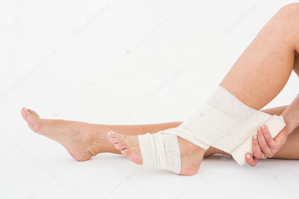 Sitting woman banding her ankle Stock Photo by ©Wavebreakmedia 73422757